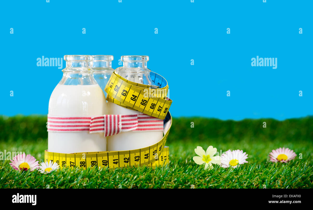 three small bottles of milk with a tape measure Stock Photo - Alamy