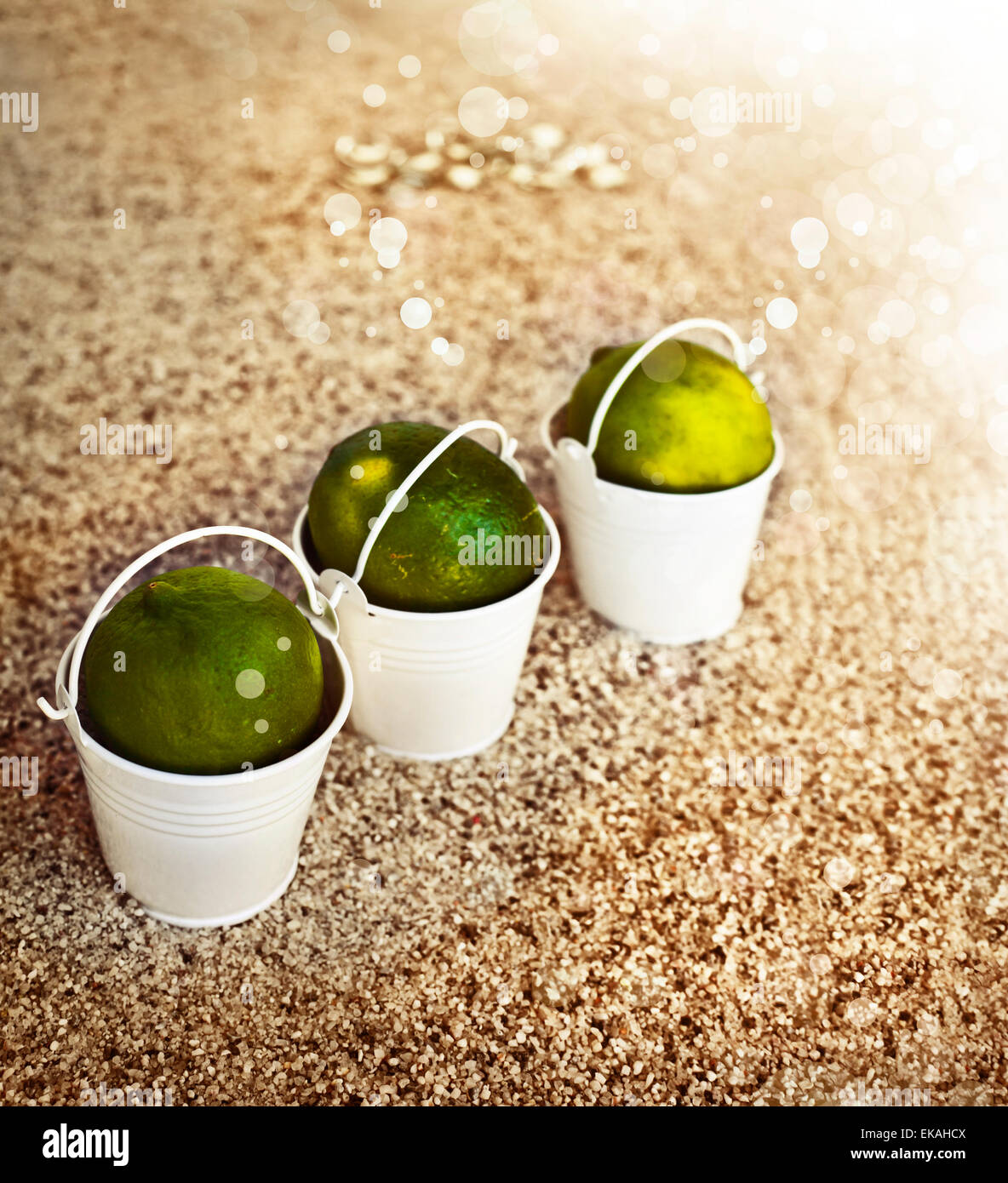 Little white buckets with limes on the sandy beach. Summer holiday ...