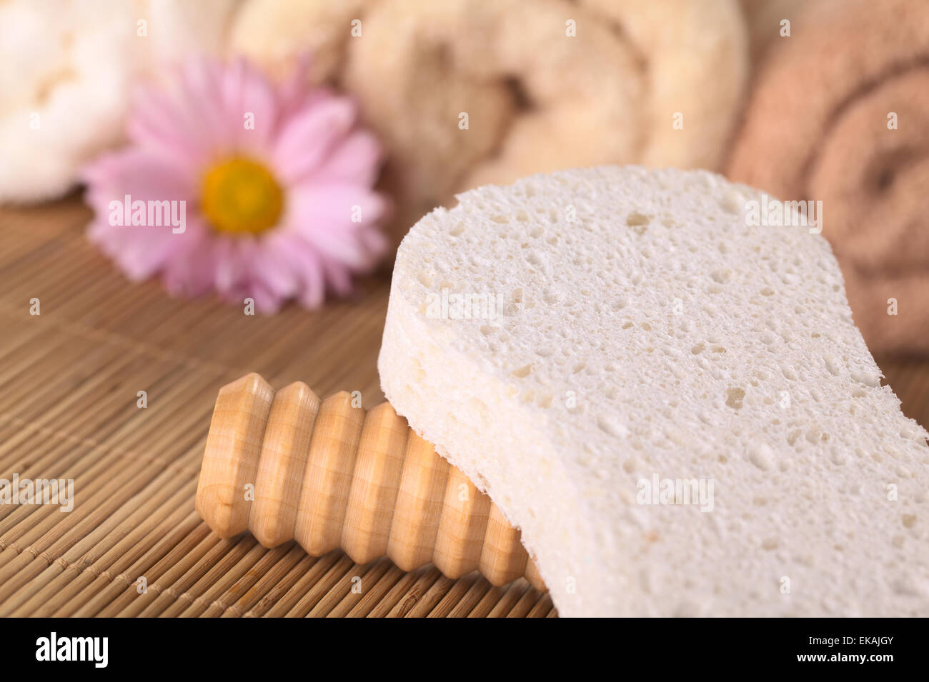 Spa still life with a wooden massage roll, sponge, flower and towels in ...