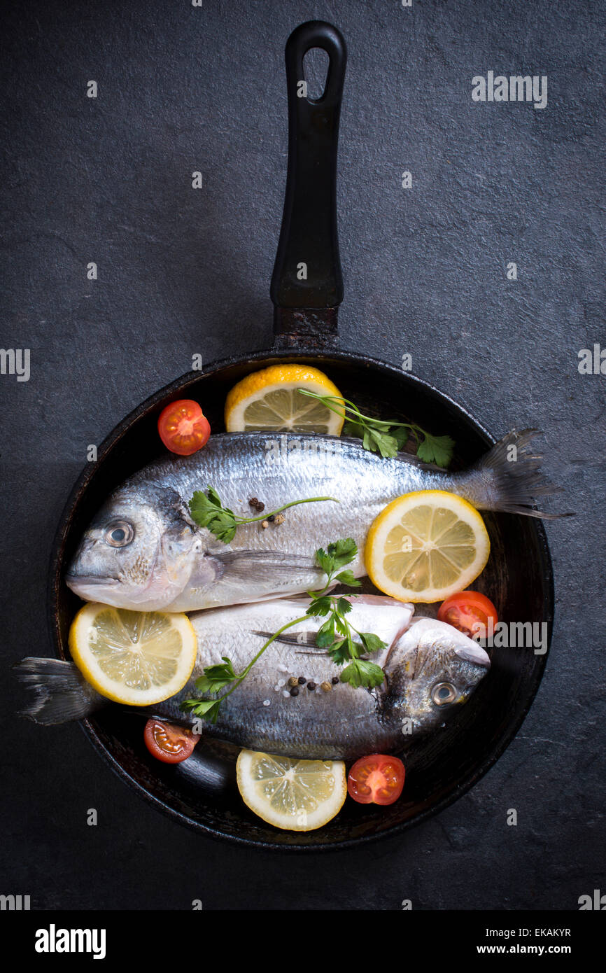 Dorada fish in the pan with ingredients from above Stock Photo - Alamy