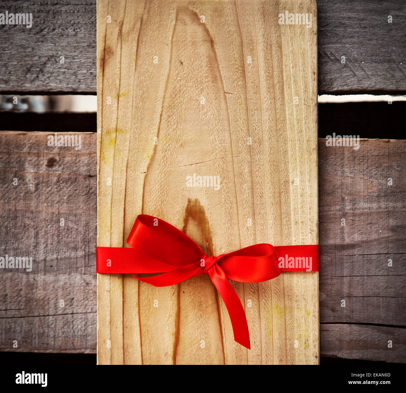 Red Bow And Blank Gift Tag With Wooden Wall Stock Photo - Alamy