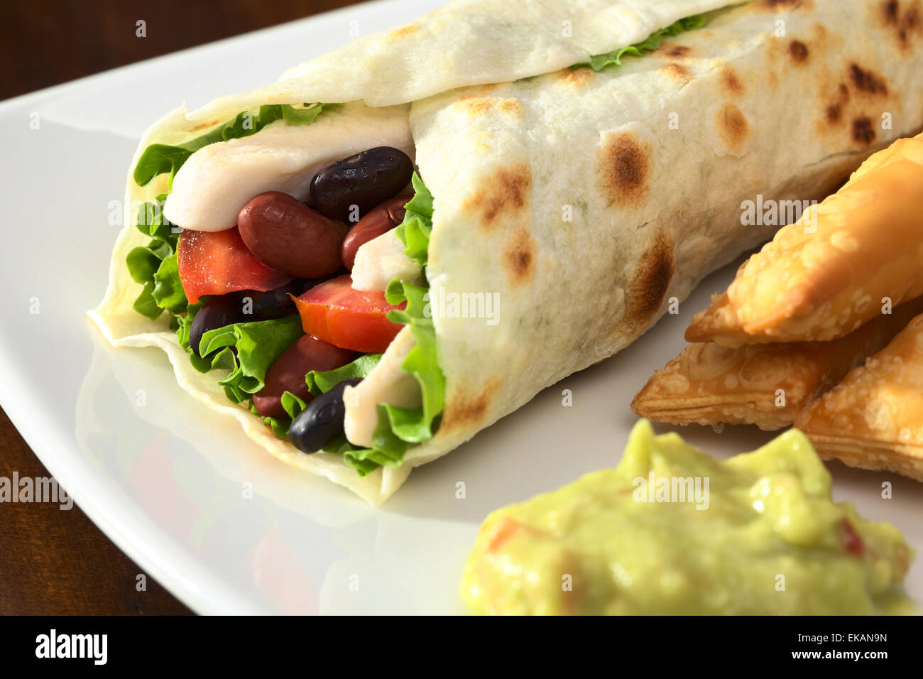 Mexican tortilla wraps filled with chicken, beans, tomato and lettuce ...