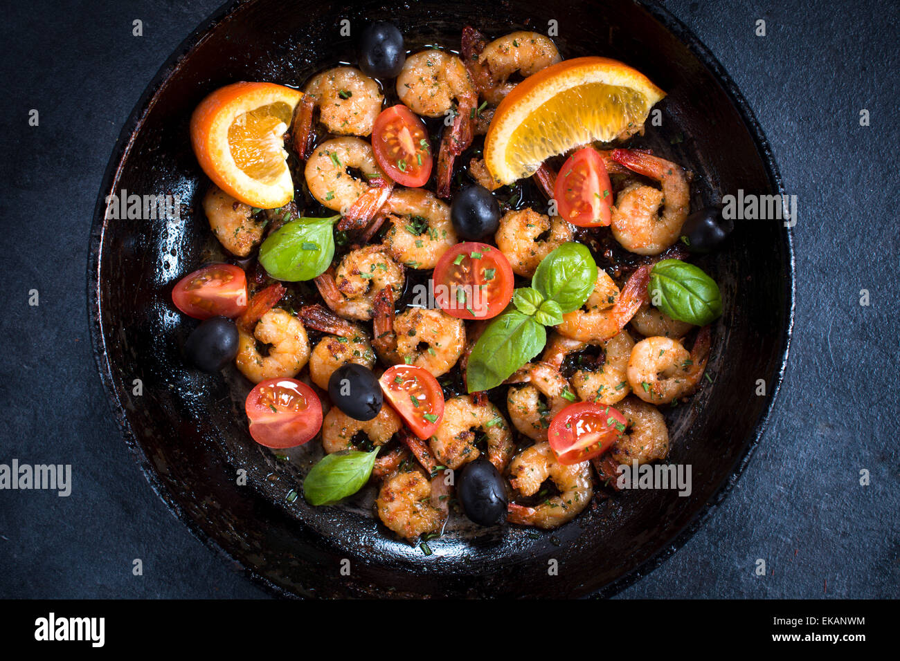 Fried tiger shrimps with ingredients in the pan from above on dark ...