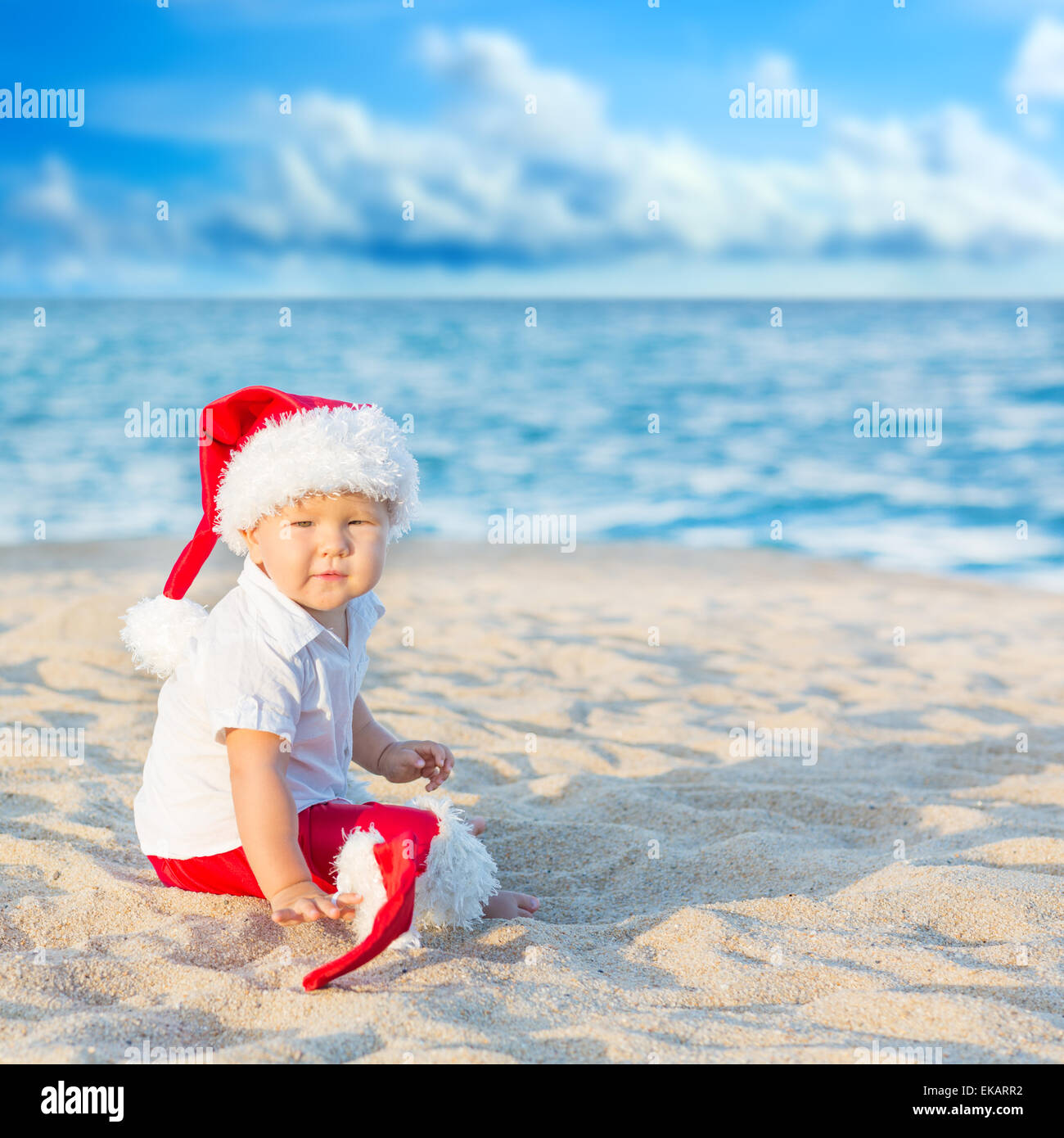 Little Santa boy on the beach Stock Photo - Alamy