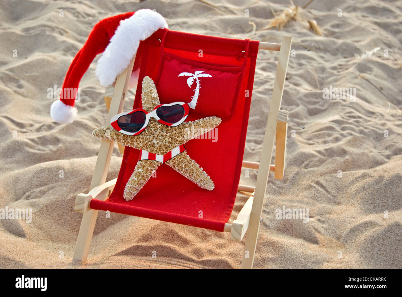 Christmas starfish with striped bikini and sunglasses on a chaise ...