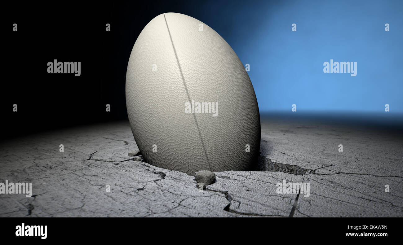 A white dimpled rugby ball stuck in a whole cracked in the ground on a ...