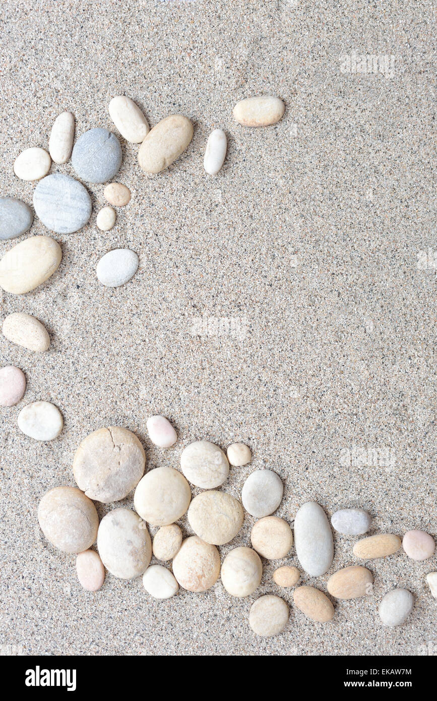 few stones on beach sand with a bright background Stock Photo - Alamy