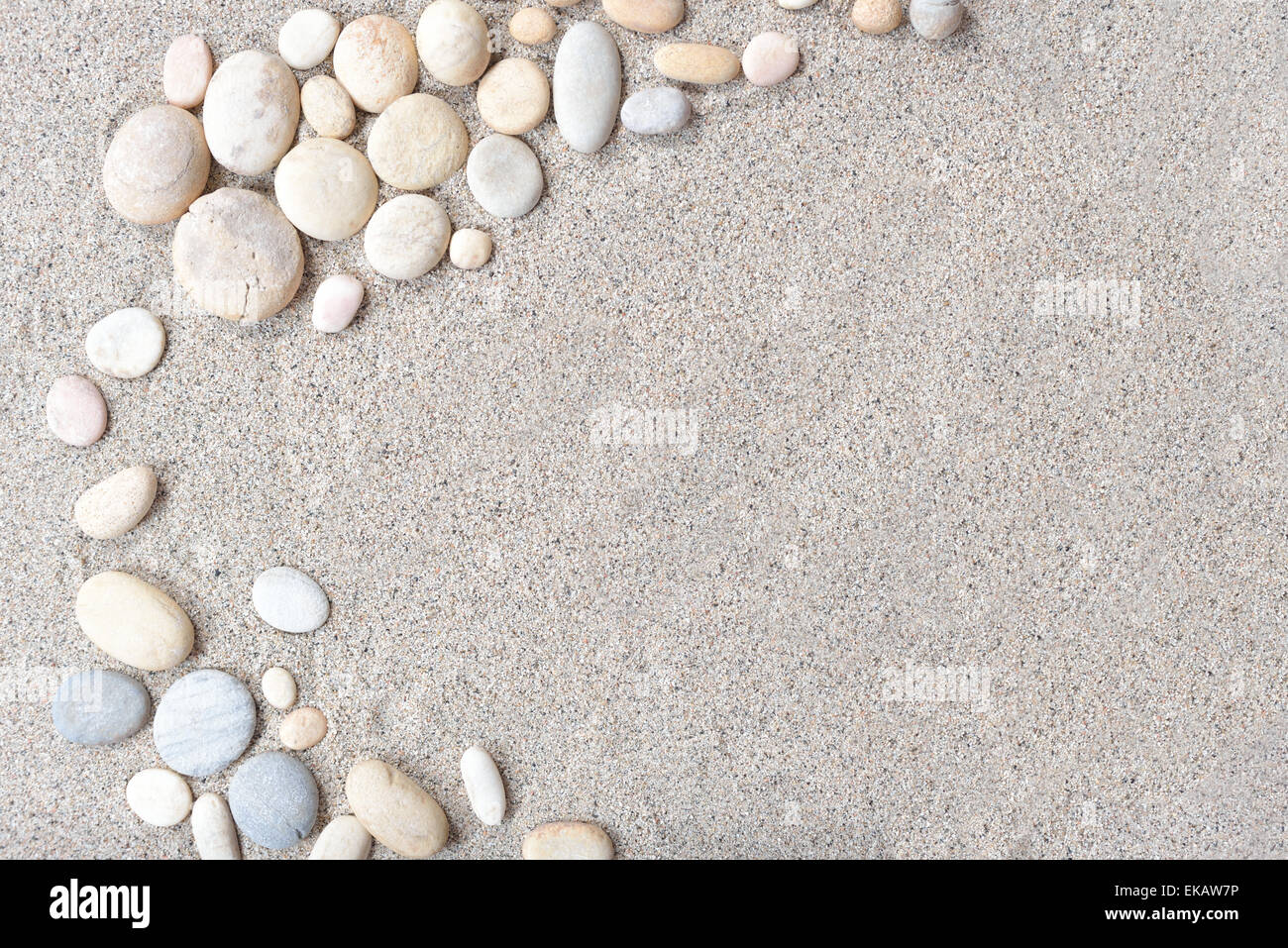 few stones on beach sand with a bright background Stock Photo - Alamy