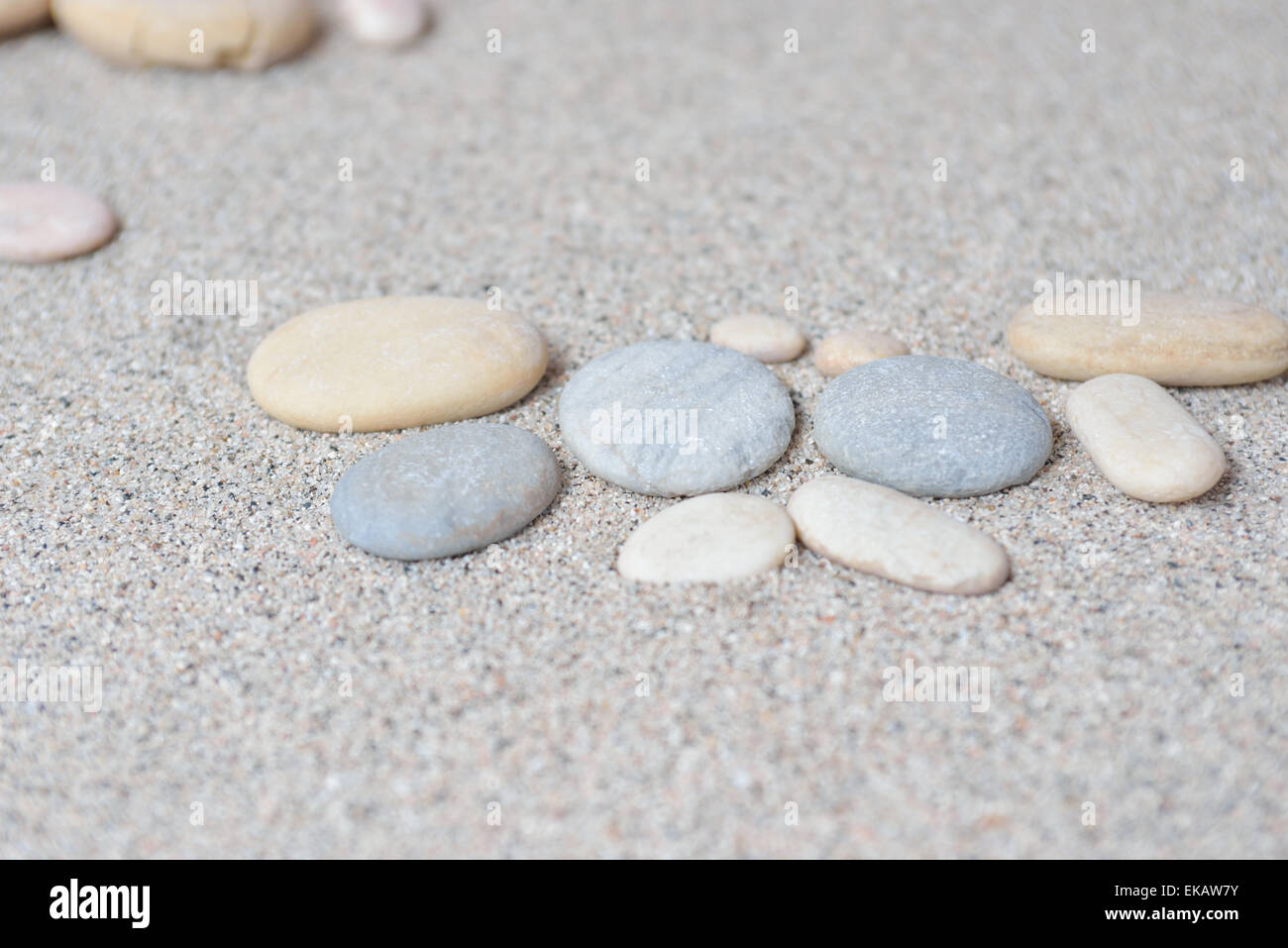 few sand stones on beach sand with a bright background Stock Photo - Alamy