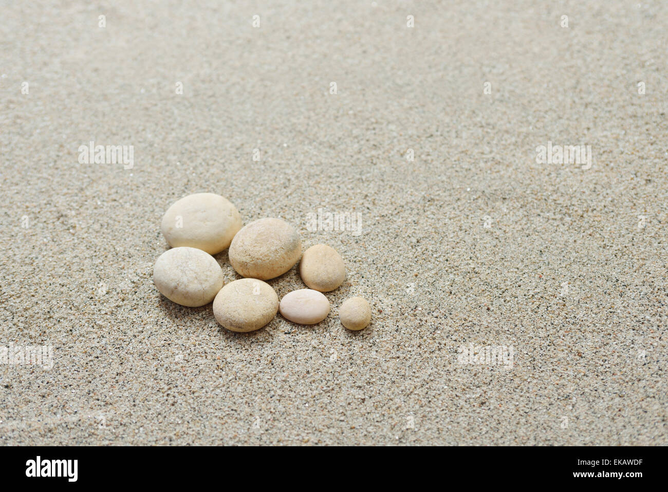 few sand stones on beach sand with a bright background Stock Photo - Alamy