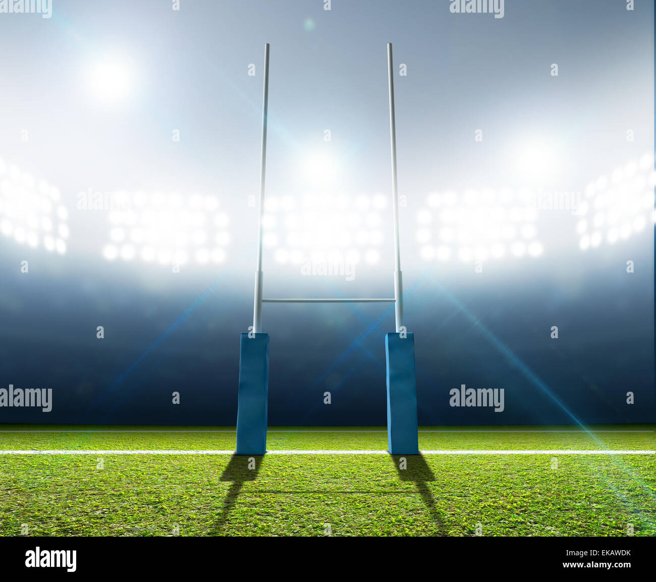 A rugby stadium with rugby posts on a marked green grass pitch at night ...