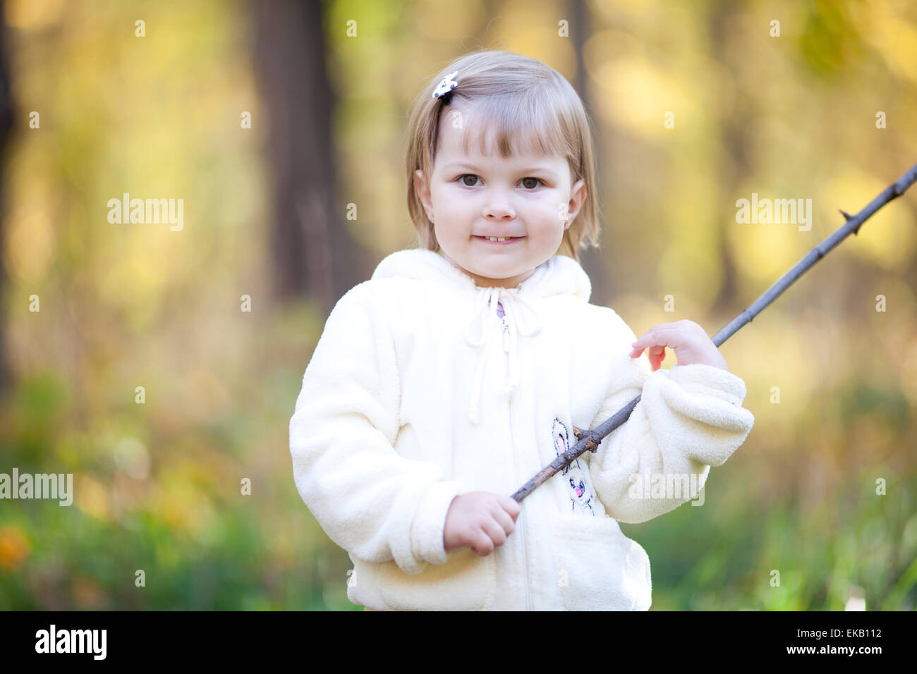 beautiful little girl with a stick on the autumn forest Stock Photo - Alamy