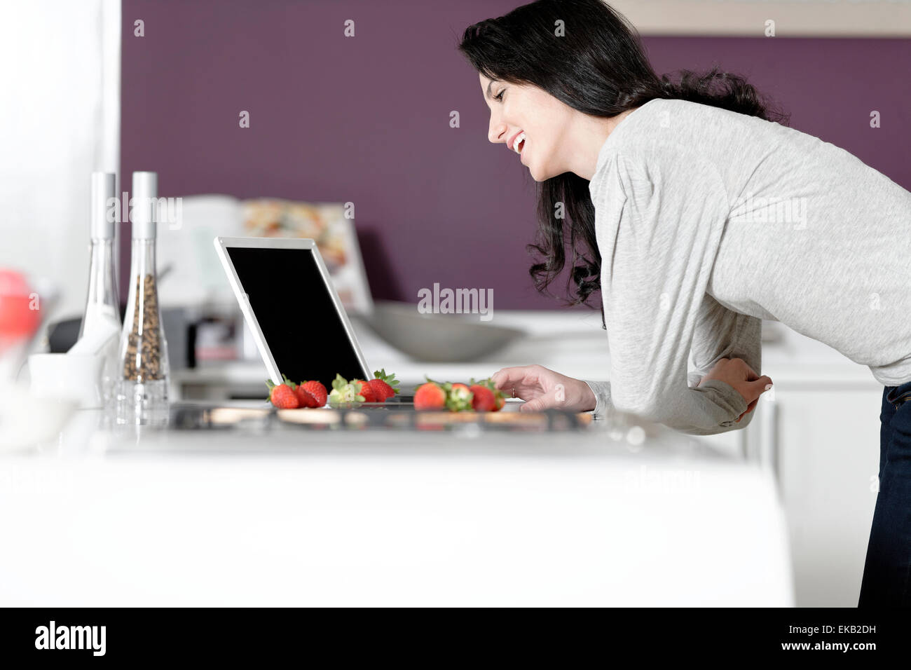 Woman in kitchen reading recipe Stock Photo - Alamy