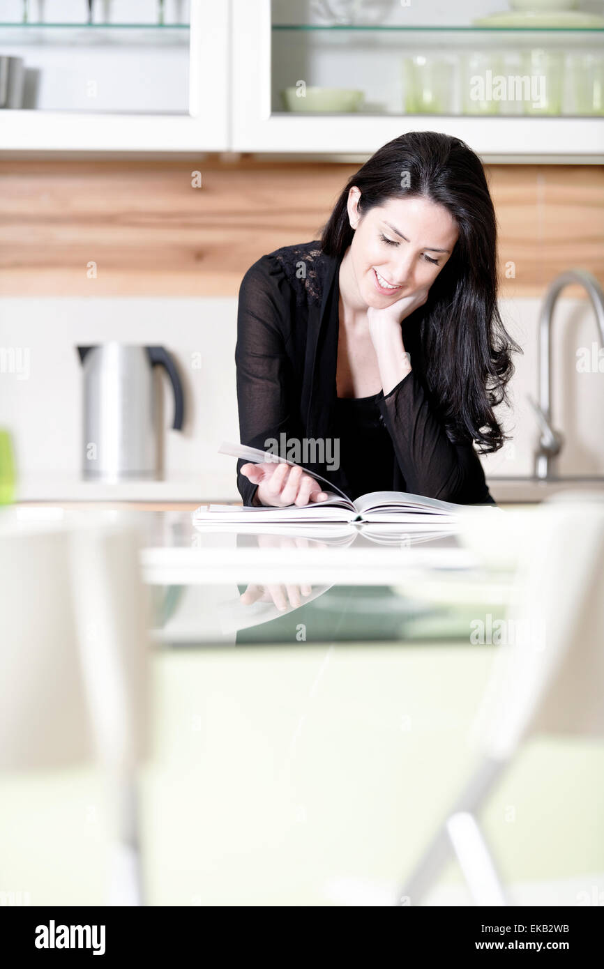 Woman reading recipe book Stock Photo - Alamy