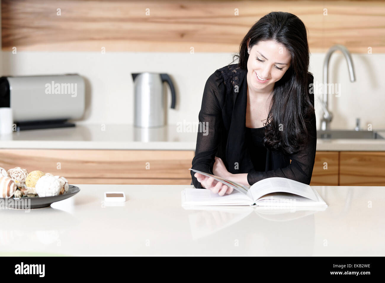 Woman reading recipe book Stock Photo - Alamy