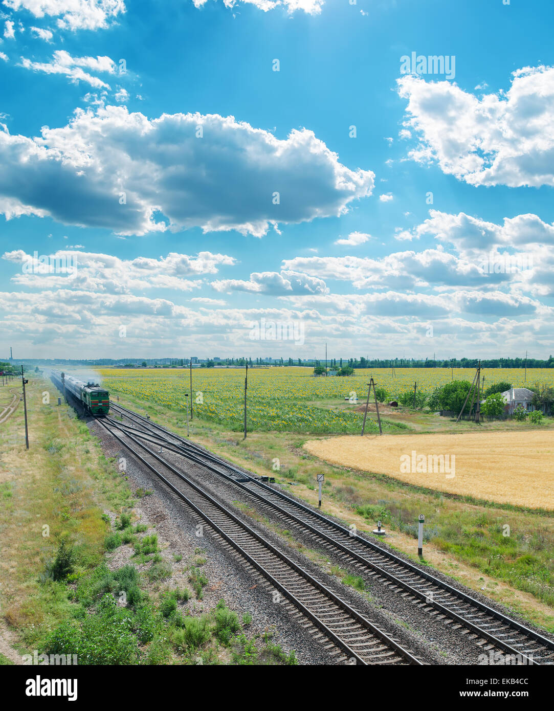 railroad with train under cloudy sky Stock Photo - Alamy