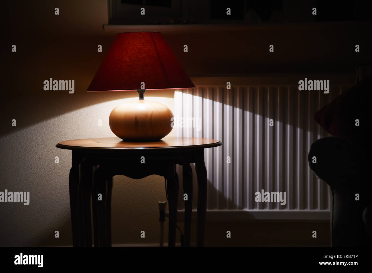 Living room lamp on a table switched on in dark corner Stock Photo - Alamy