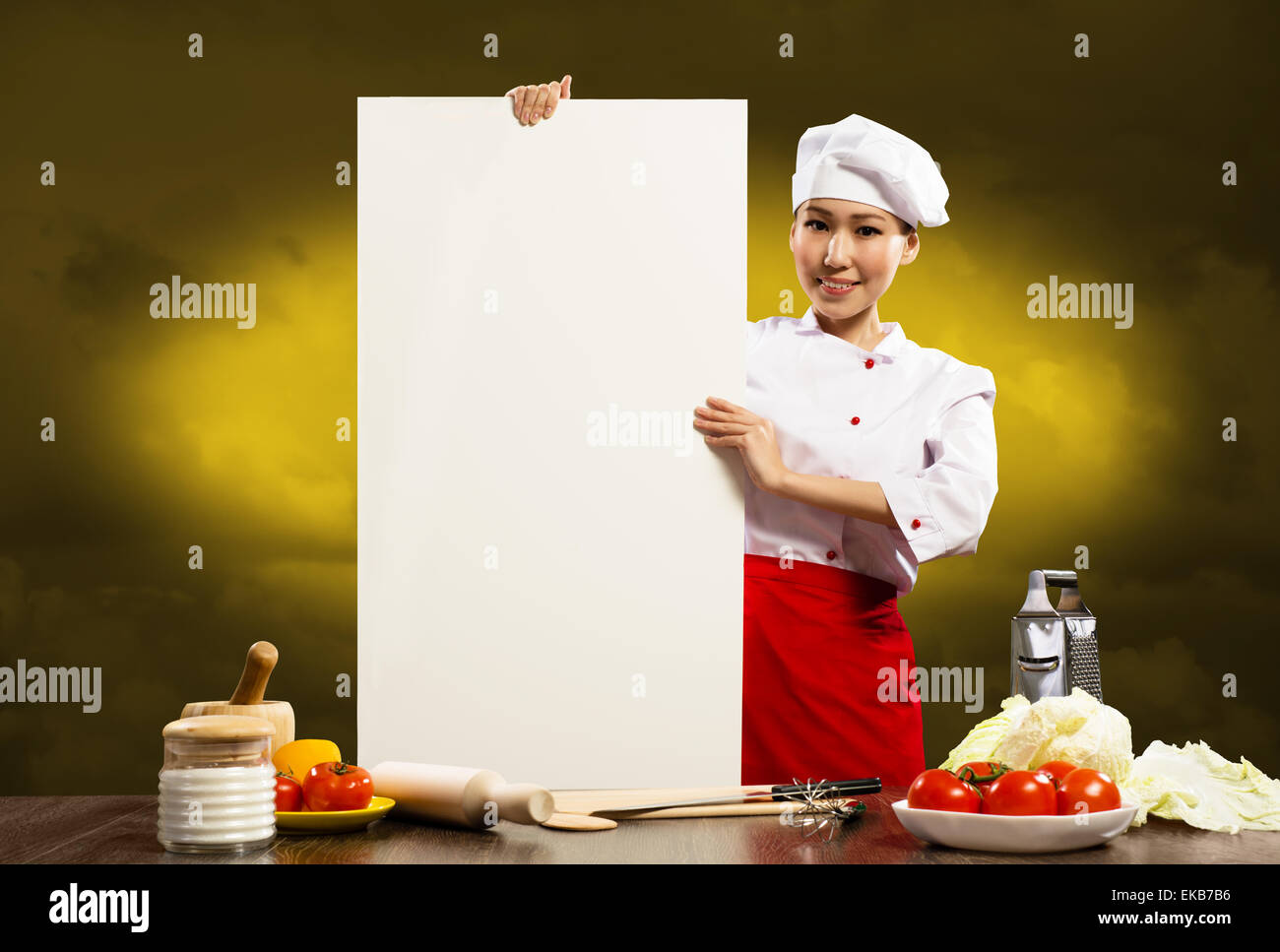 female chef holding a poster for text Stock Photo - Alamy