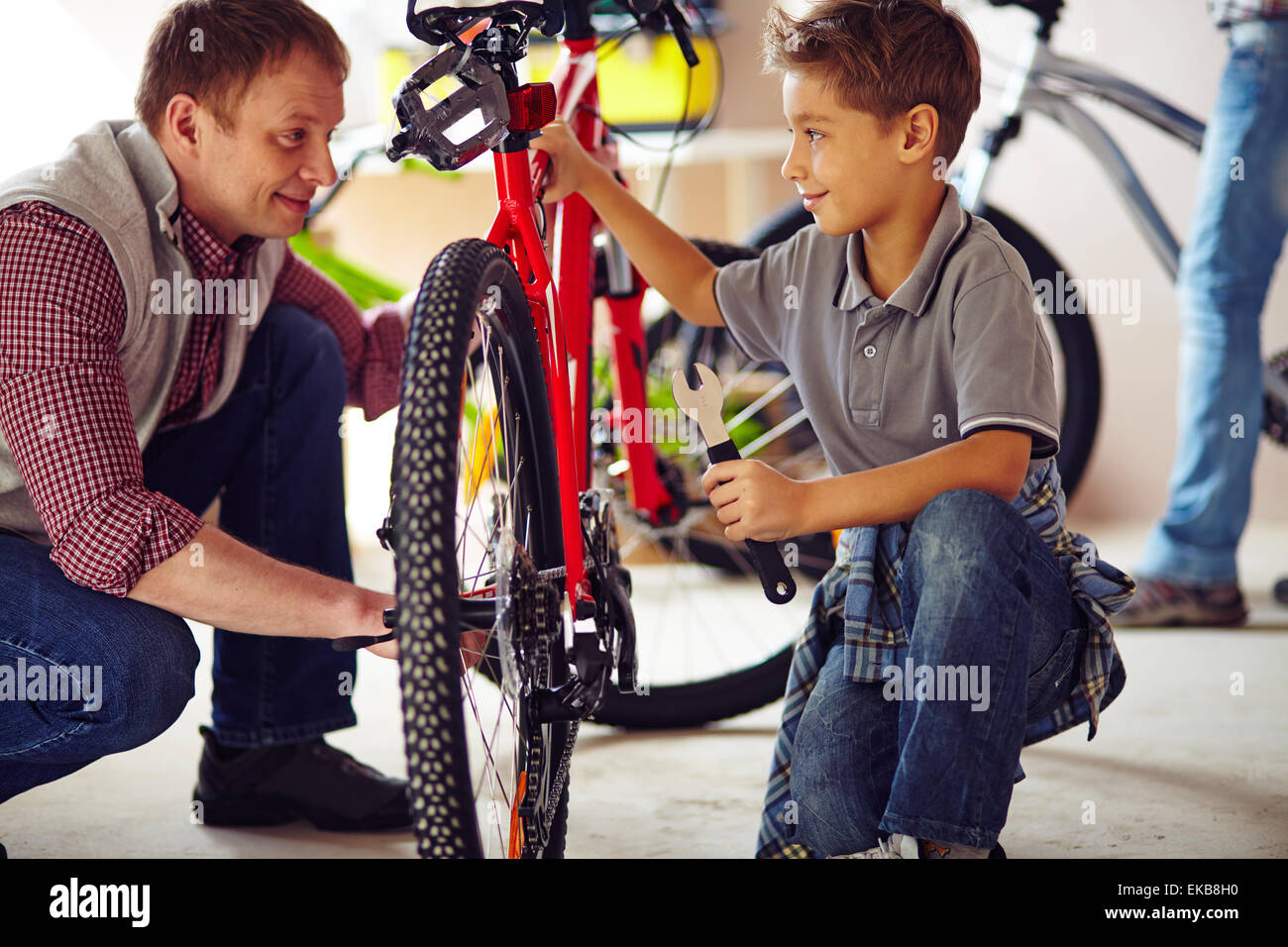 Young man showing his son how to repair bike Stock Photo - Alamy