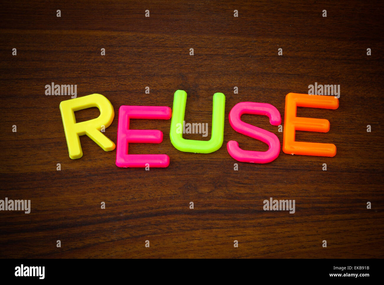 Reuse in colorful toy letters on wood background Stock Photo - Alamy