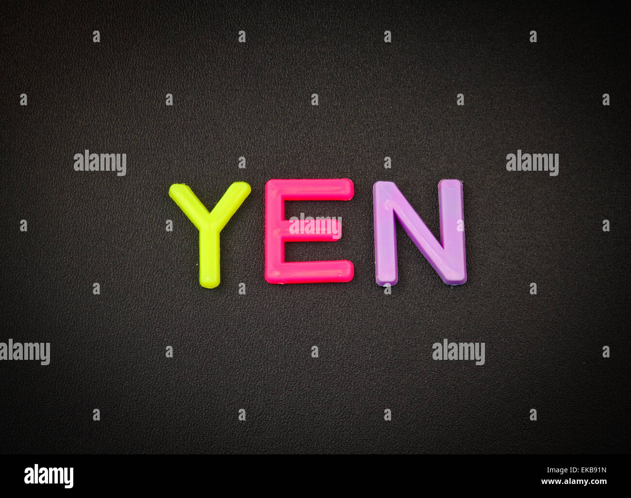 Yen in colorful toy letters on black background Stock Photo - Alamy