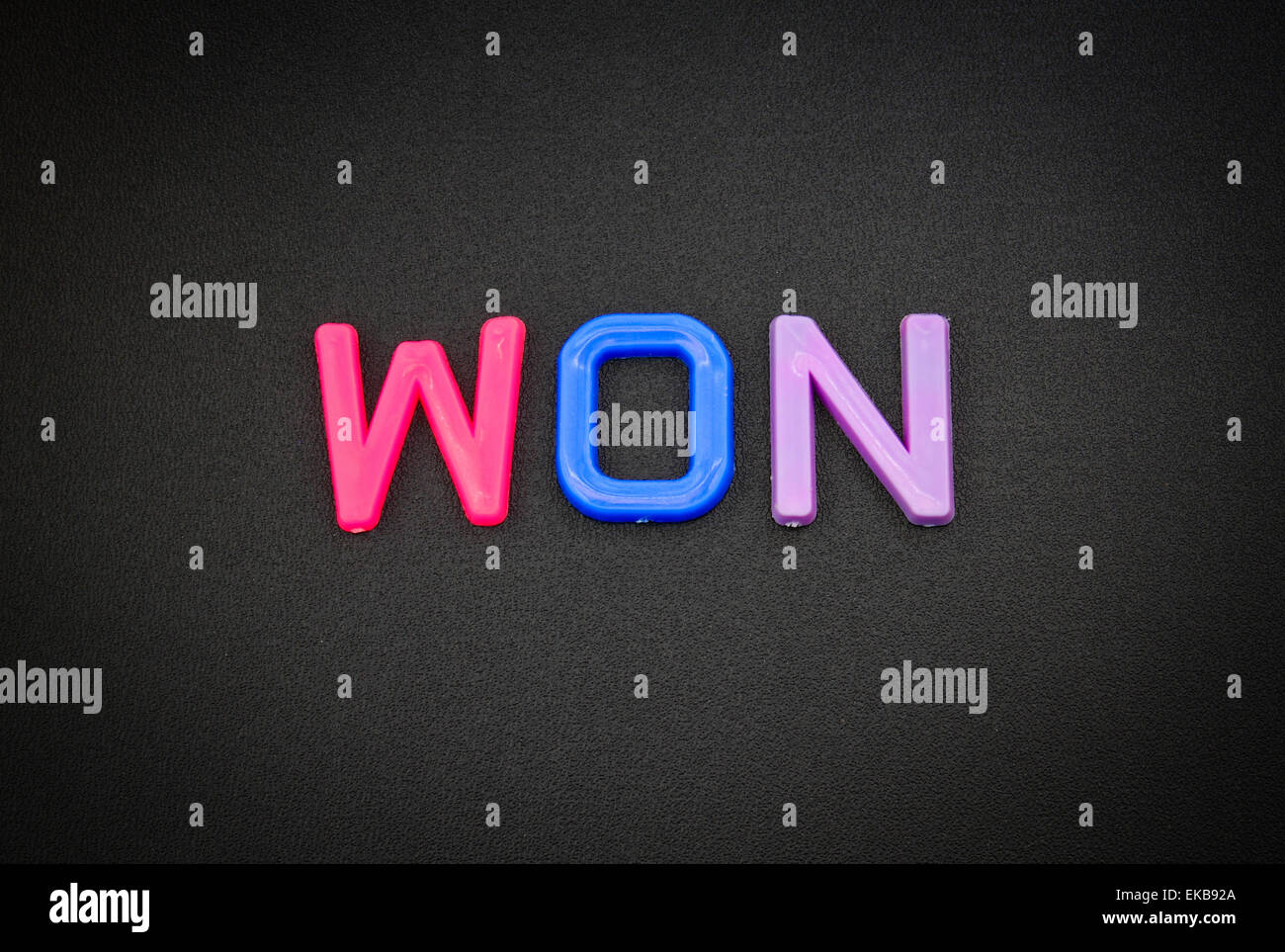Won in colorful toy letters on black background Stock Photo - Alamy