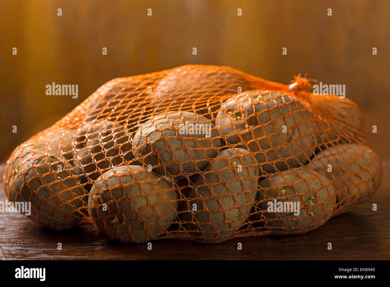 Potatoes in bag on wooden table Stock Photo - Alamy