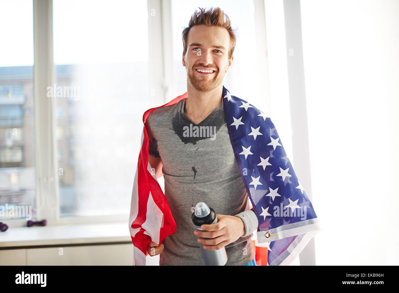 Young man wrapped in USA flag looking at camera Stock Photo - Alamy