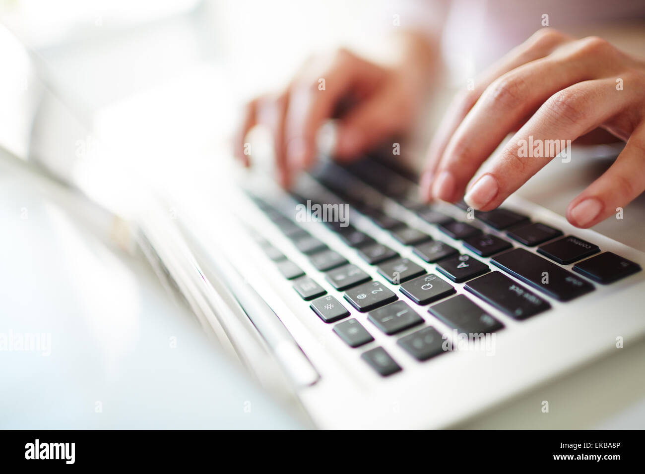 Fingers of female over laptop keypad Stock Photo - Alamy