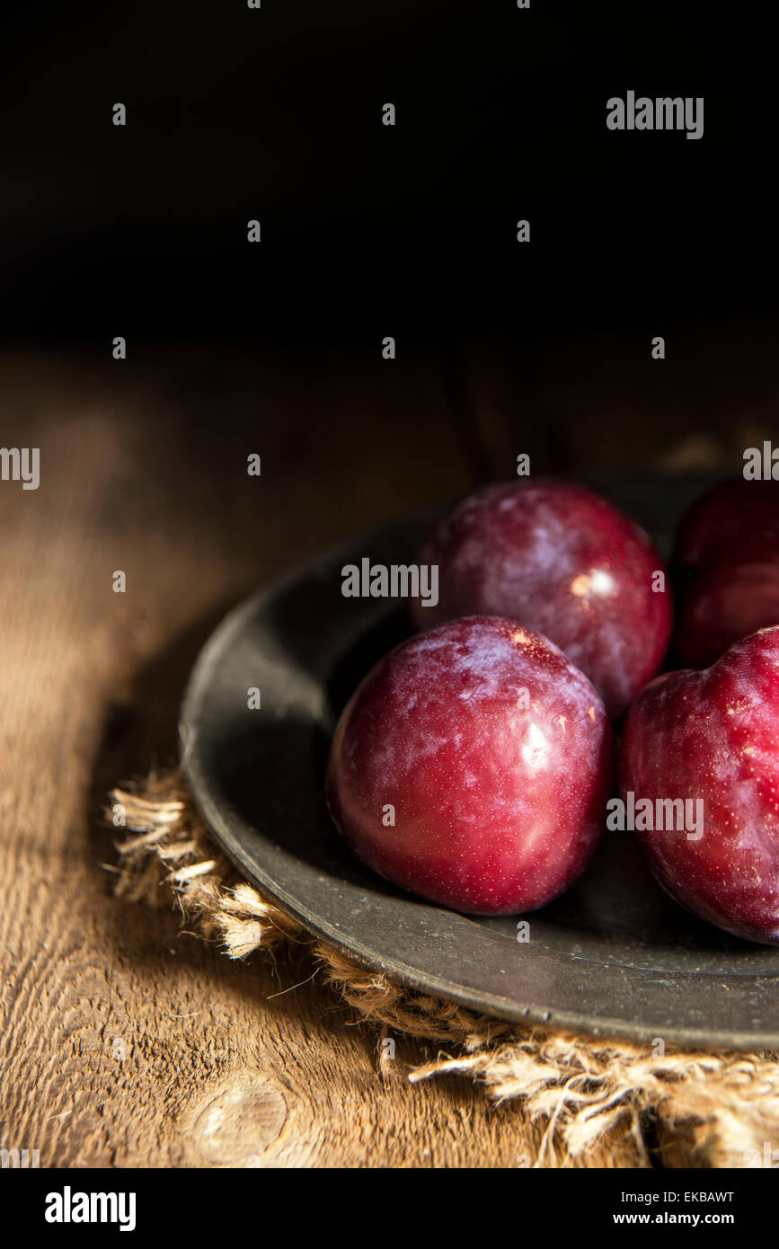Fresh plums in natural light setting with moody vintage style Stock ...