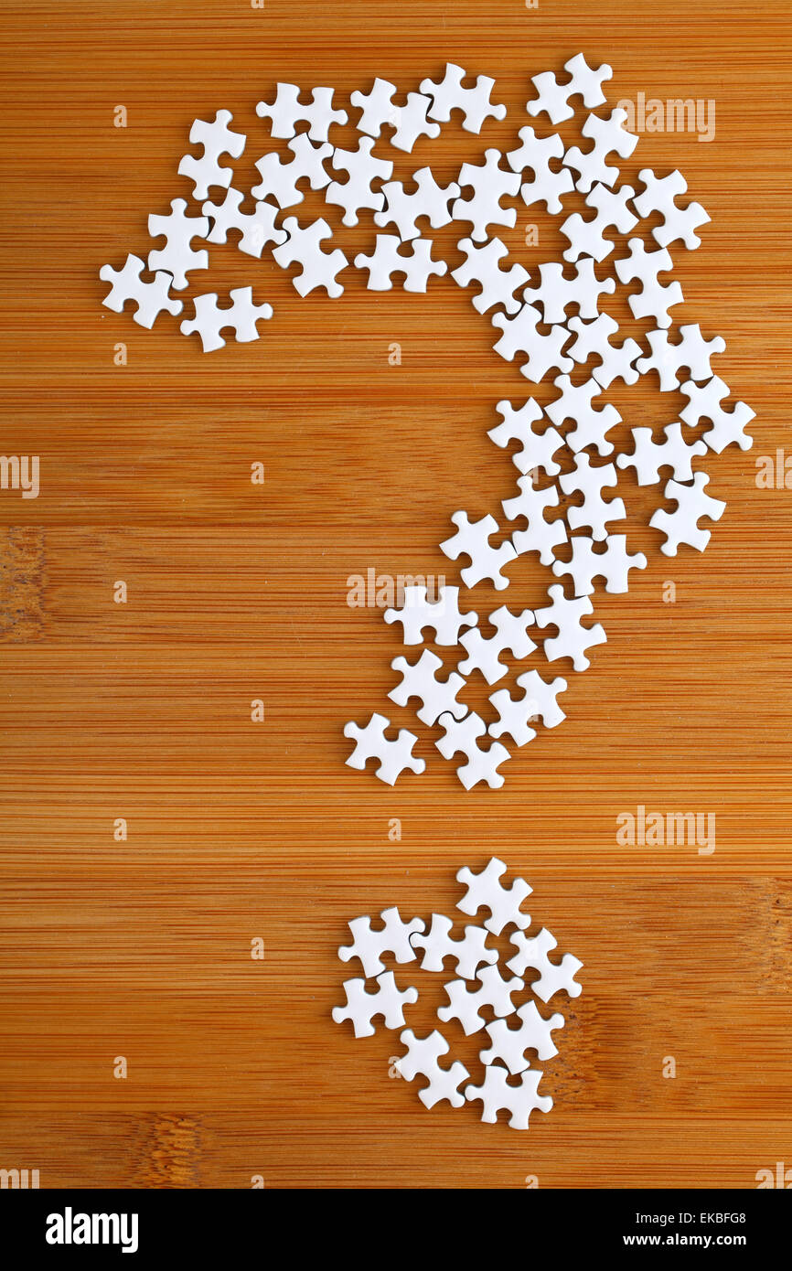 question mark made by puzzle on wood background Stock Photo - Alamy