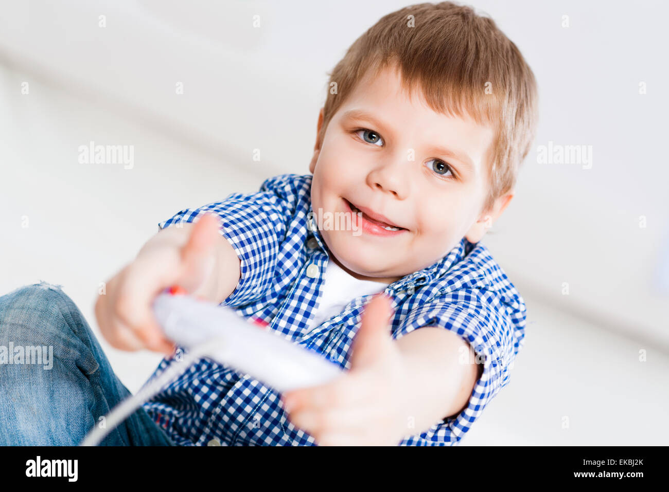 Boy playing on a game console Stock Photo - Alamy