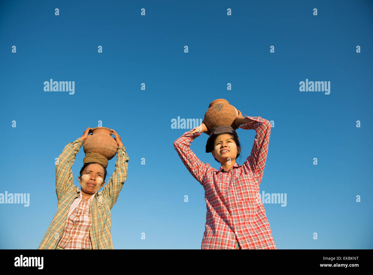 Asian traditional farmers carrying pot on head Stock Photo - Alamy