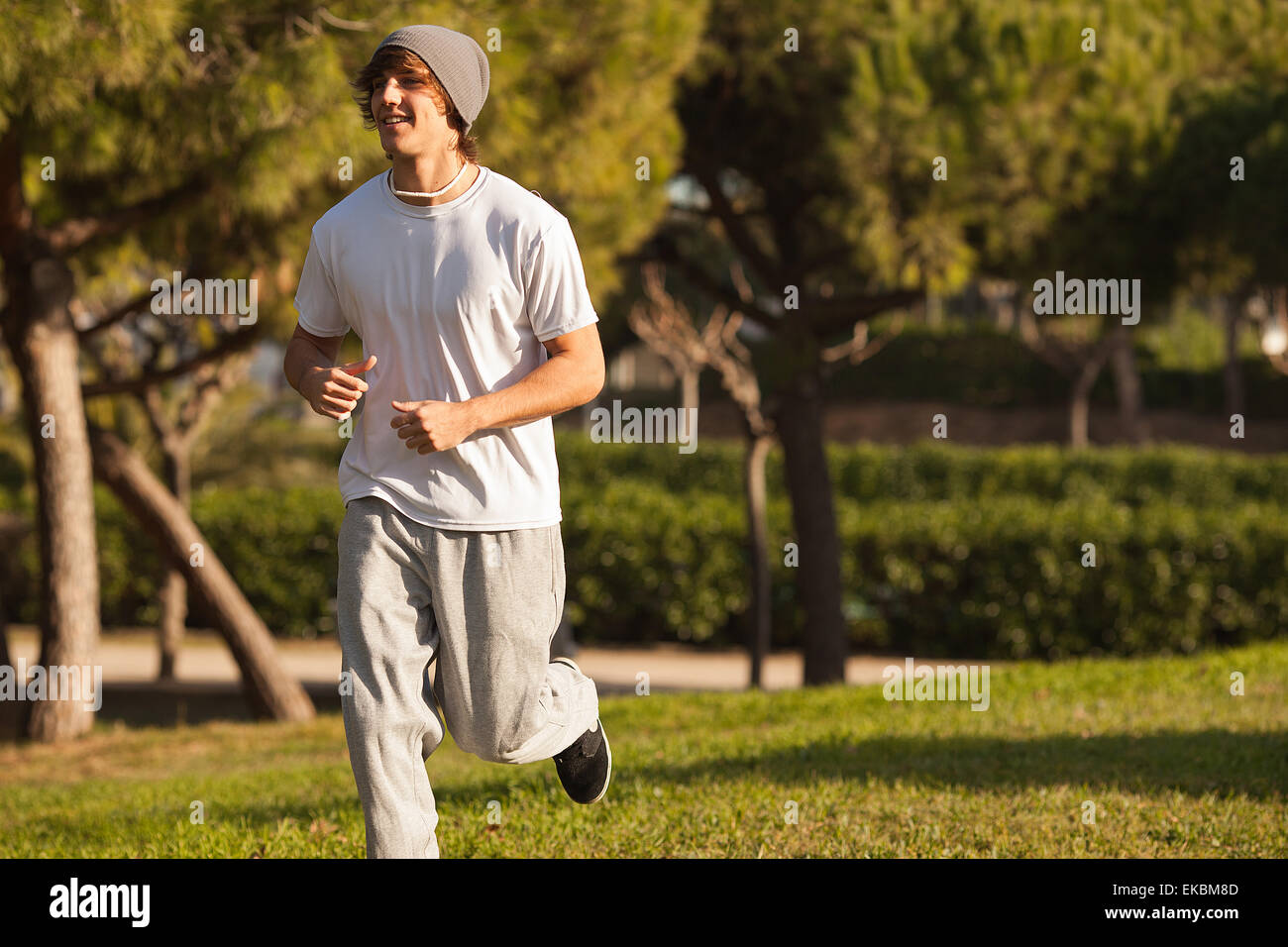 young handsome man jogging in public park Stock Photo - Alamy