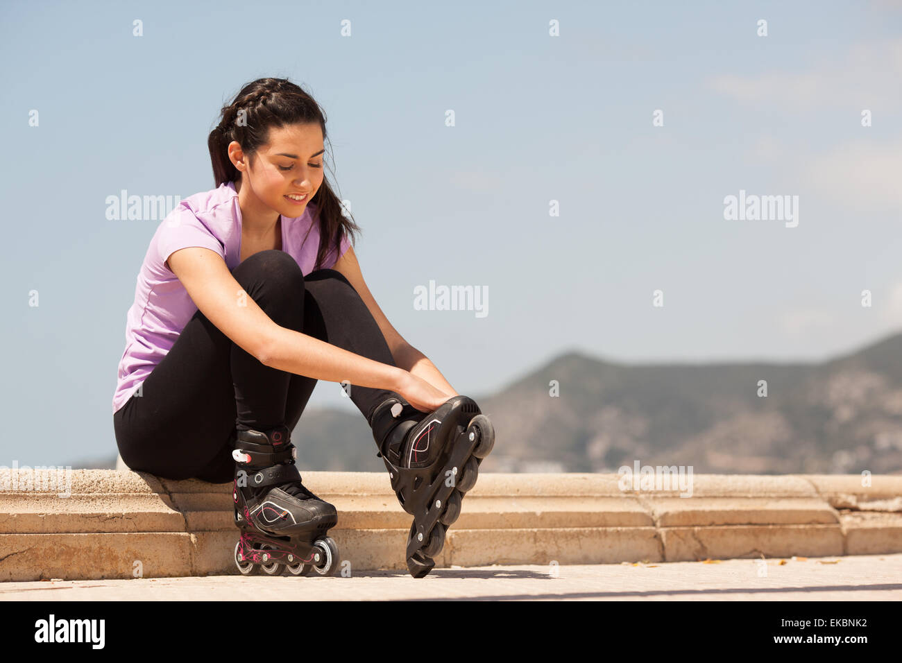 Girl going rollerblading sitting putting on inline skates Stock Photo ...