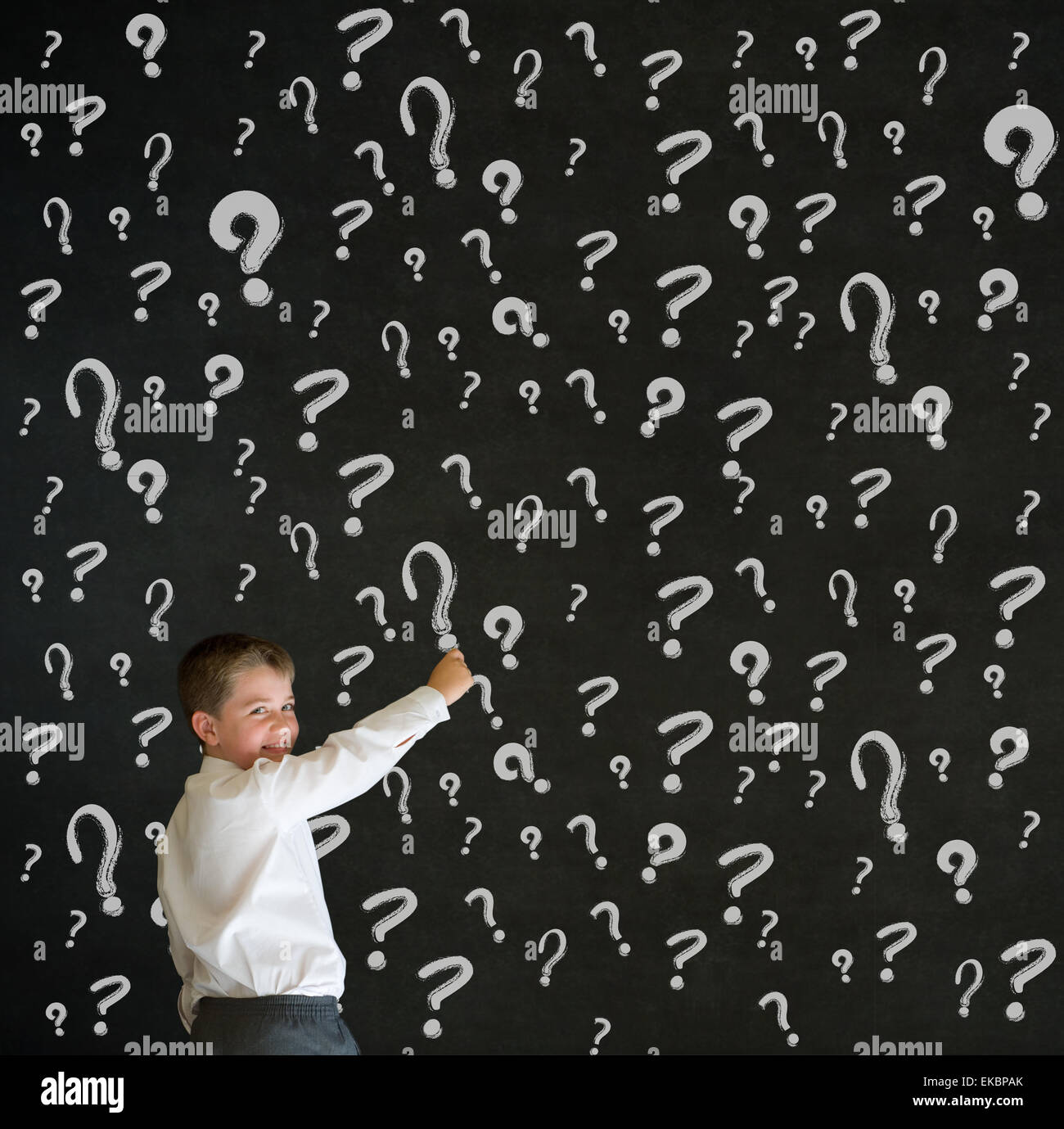 Writing boy dressed as business man with chalk question marks Stock ...