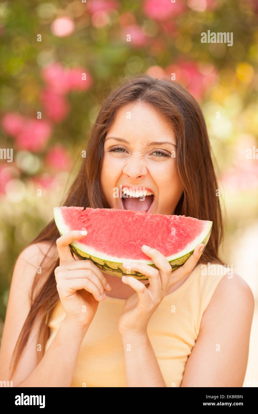 Portrait of a beautiful young woman eating watermelon Stock Photo - Alamy