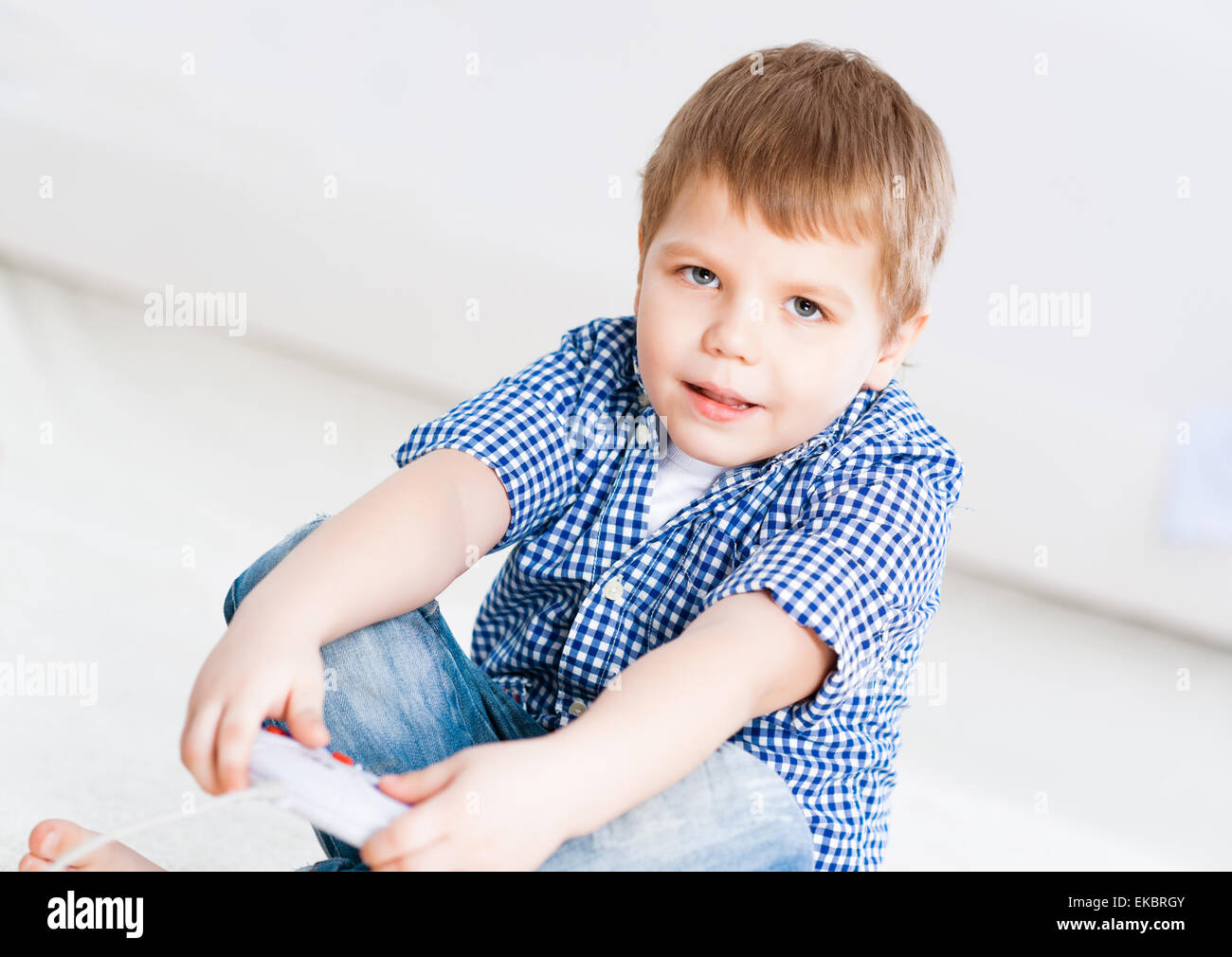 Boy playing on a game console Stock Photo - Alamy