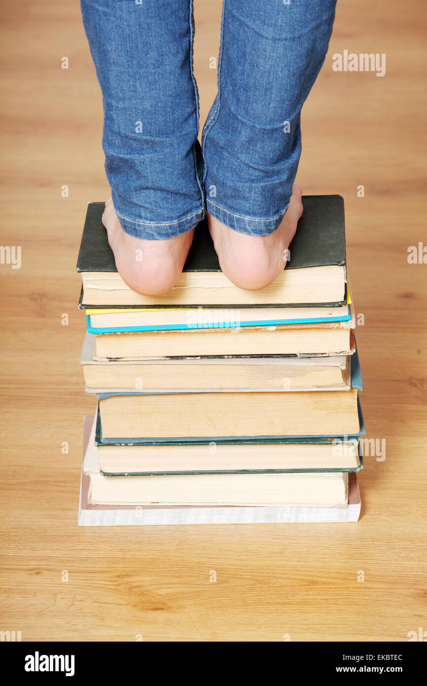 Girl standing on books Stock Photo - Alamy