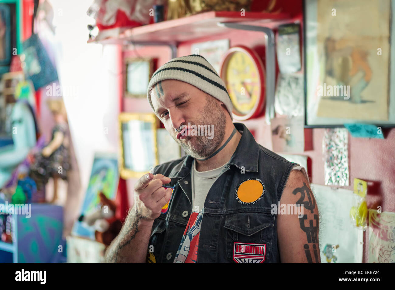 Portrait of male punk shop keeper winking in vintage toy shop Stock ...