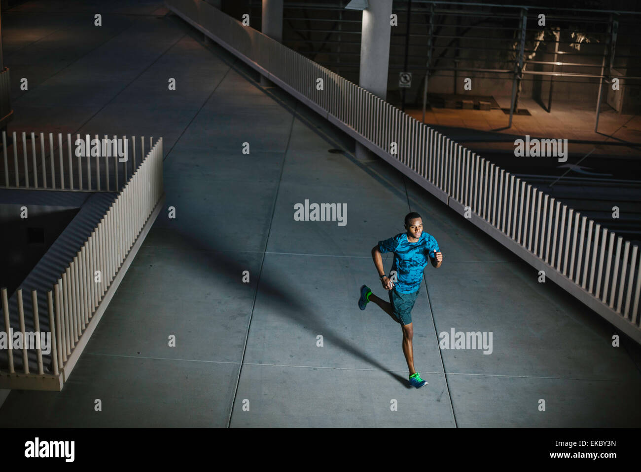 High angle view of young man running on city walkway at night Stock ...