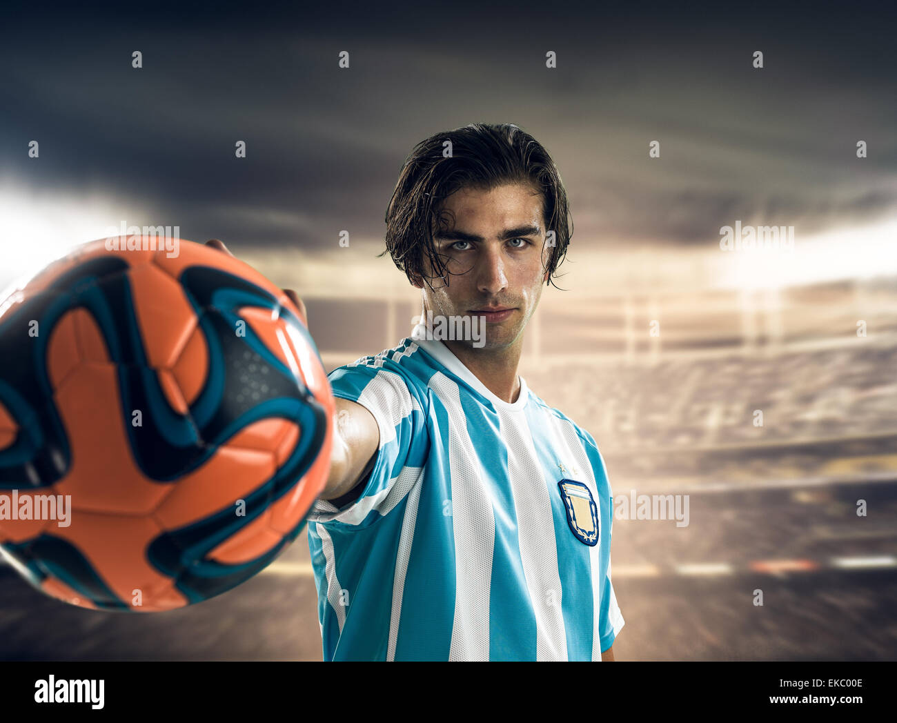 Footballer holding ball Stock Photo - Alamy