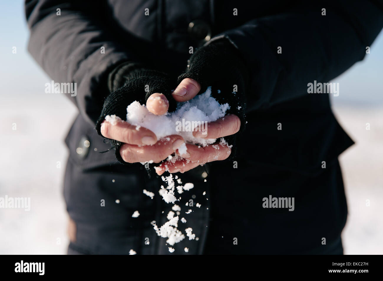 Woman holding snow in hands Stock Photo - Alamy