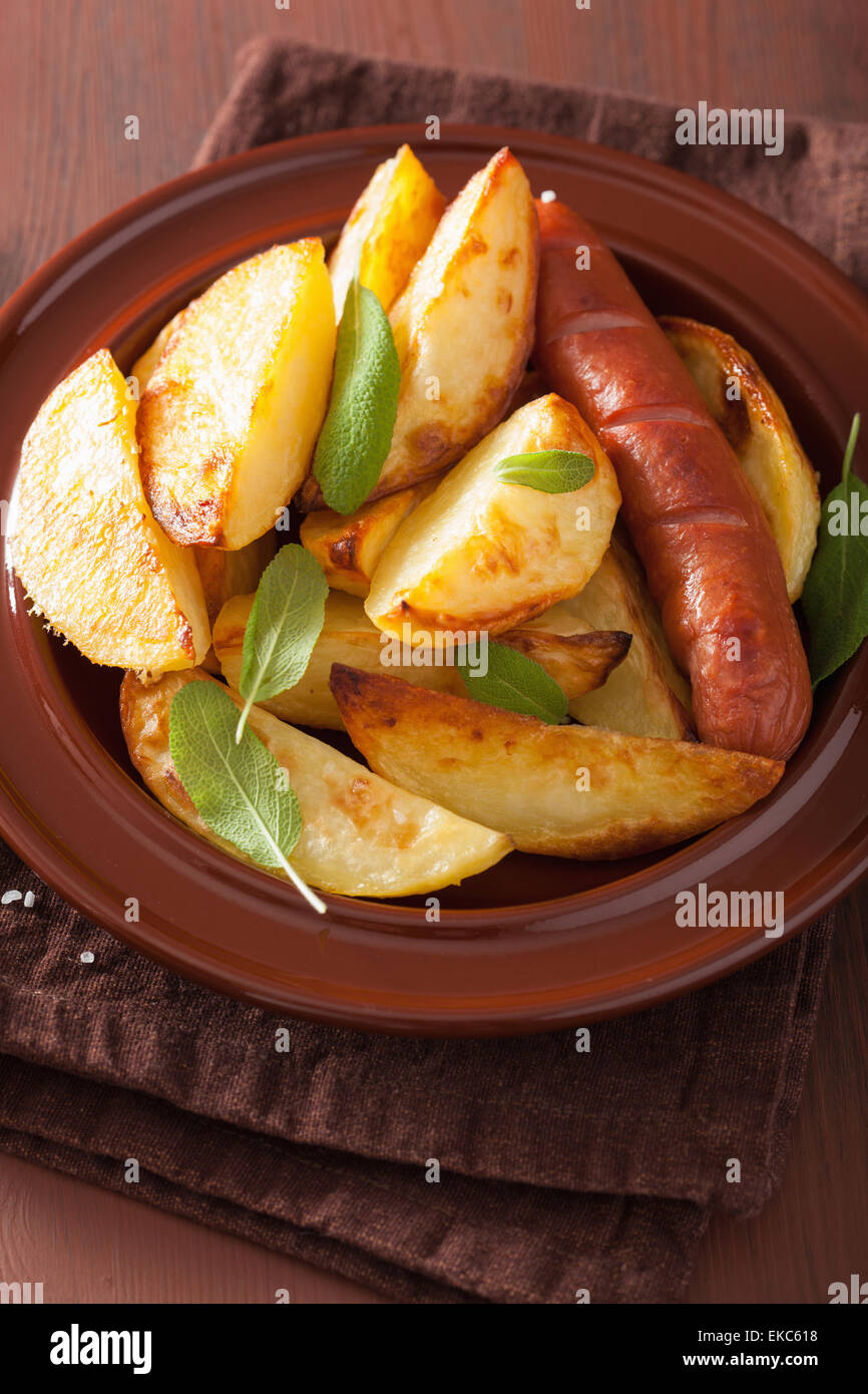 baked potato wedges and sausage in plate over brown rustic table Stock ...