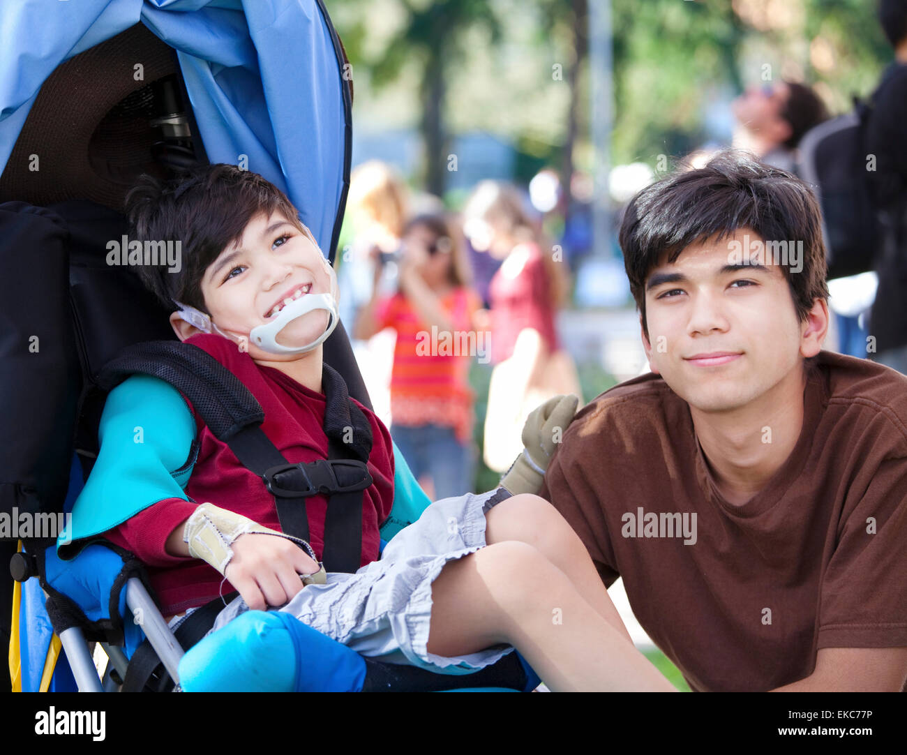 Big brother taking care of disabled little boy in wheelchair Stock ...