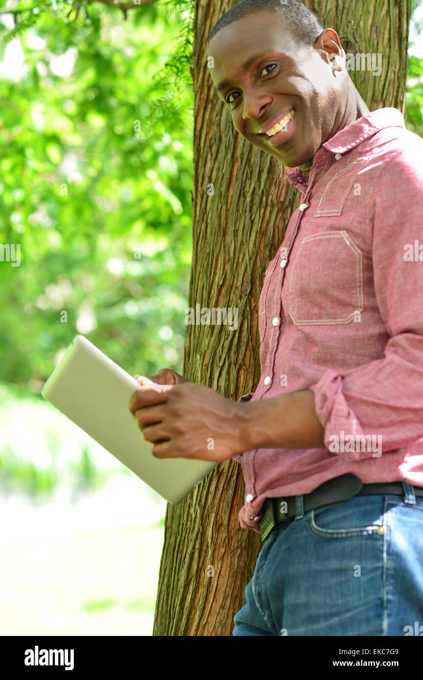 Relaxed smiling man using his digital tablet Stock Photo - Alamy