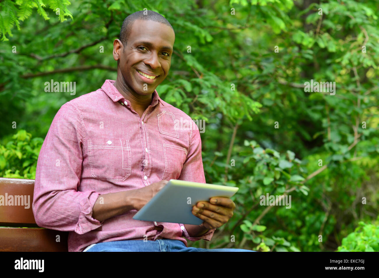 Happy guy using his tablet pc, outdoors Stock Photo - Alamy