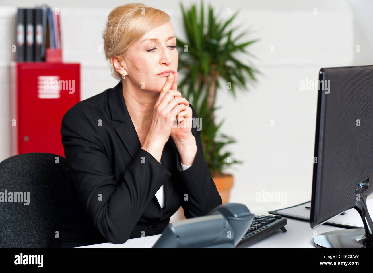 Corporate lady looking into computer screen Stock Photo - Alamy