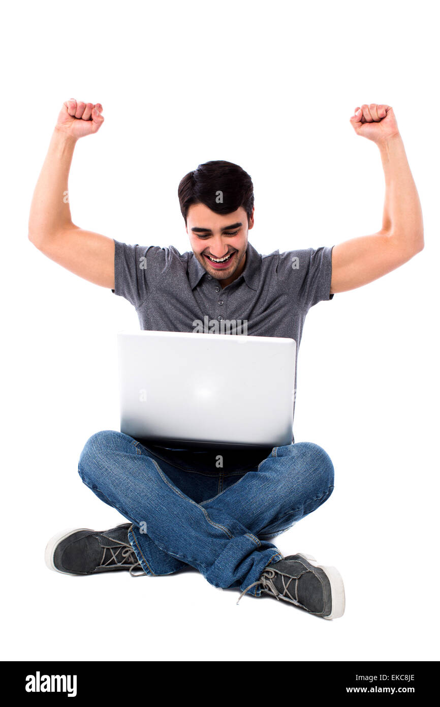 Excited young guy with laptop Stock Photo - Alamy