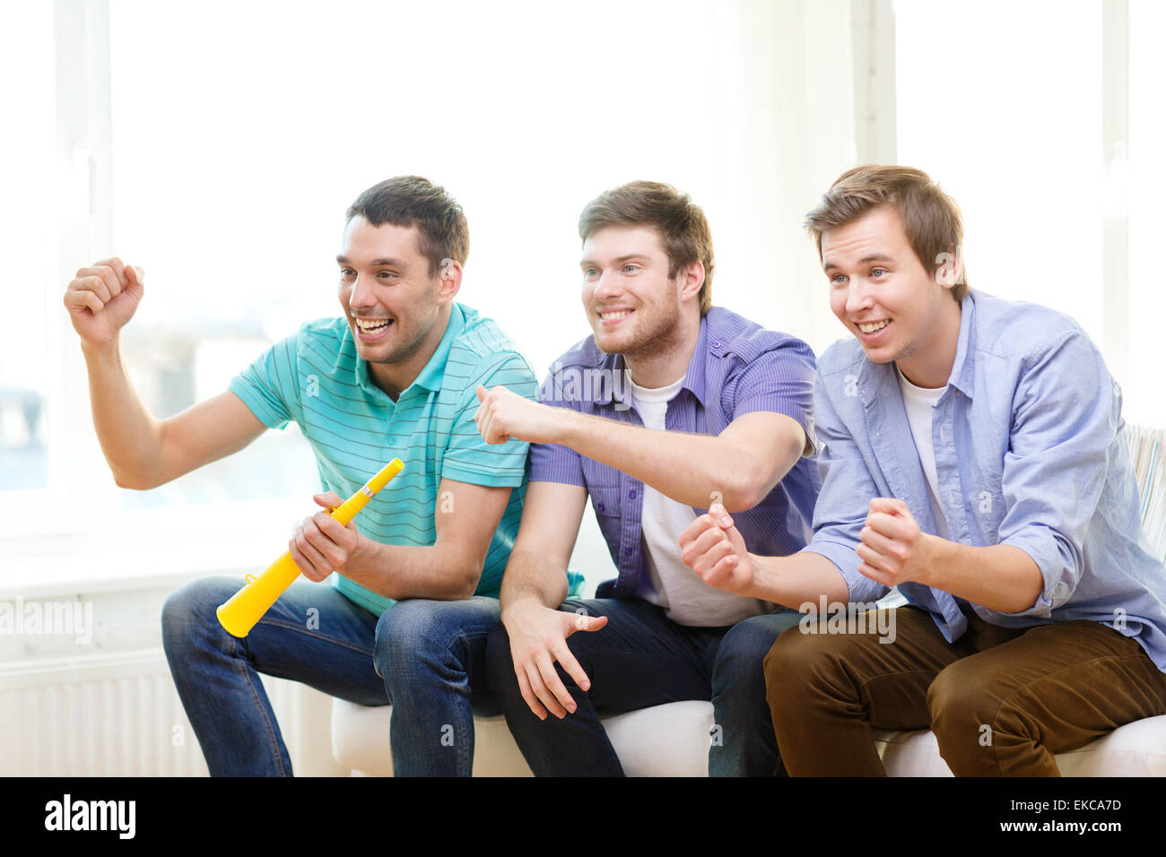 happy male friends with vuvuzela watching sports Stock Photo - Alamy